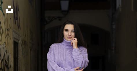 보라색 스웨터와 파란색 데님 청바지를 입은 여자가 복도에 서 있다 사진 Unsplash의 무료 브라티슬라바 이미지