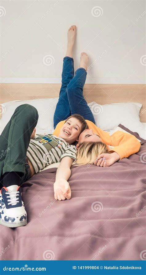 Madre Con Il Figlio Sul Divertiresi Del Letto Della Madre E Del Figlio Fotografia Stock