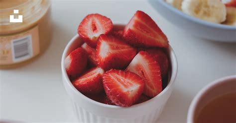 얇게 썬 바나나와 딸기 한 그릇 옆에 얇게 썬 바나나와 딸기 한 그릇 사진 Unsplash의 무료 음식 이미지