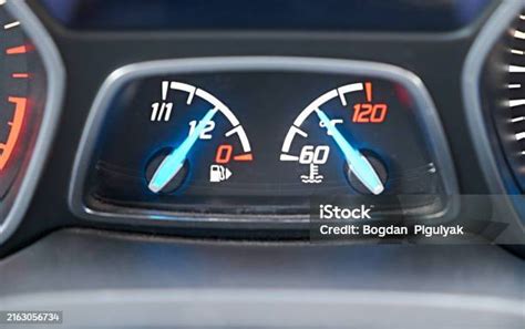 차량의 현재 연료량과 엔진 온도를 나타내는 생생한 파란색과 빨간색 강조 표시와 함께 연료 및 온도 게이지를 표시하는 자동차 대시