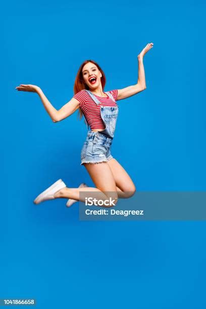 그것은 파티 타임 감정 사람 사람 카메라 개념 보고입니다 밝고 즐거운 쿨 레이디 격리 된 밝은 색 파스텔 배경 점프의 수직 전신 길이 크기 사진 초상화 멜빵 바지에 대한