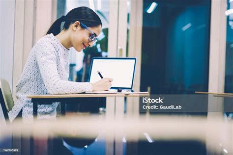 빈 화면 학습 정보를 즐기고 언어 과정에 메모를 만드는 숙련 된 여성 대학 교실 Nra 노트북에서 책상에 앉아 영리한 여성 학생 쓰기 보고서 계획에 대한 스톡 사진 및 기타