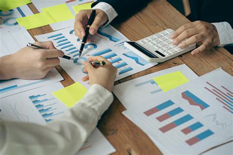 비즈니스 사람들이 디자인 아이디어 사업 계획 회의에서 펜과 그래프 종이를 들고 성공적인 팀워크를 보여주는 차트와 그래프를 논의하는 두 명의 젊은 사업가의 사진 2명에 대한