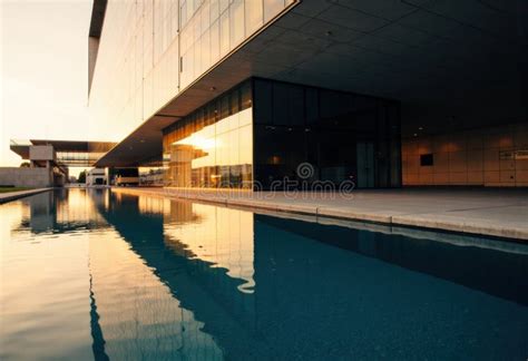 Modern Building With A Reflective Pool At Sunset Creating A Sleek Urban