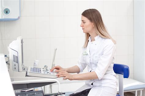 병원 병원에서 흰색 유니폼을 입은 금발의 여성 의사가 초음파 스캐너에서 작동합니다 진단 초음파 및 건강 개념 카피스파제 Stem 주제에 대한 스톡 사진 및 기타 이미지