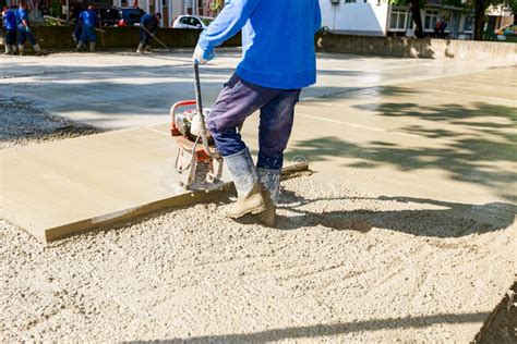 Worker Is Using Power Tool With Engine Compactor For Level And Compact Fresh Concrete Stock