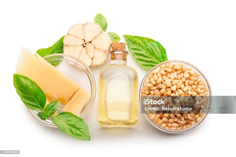 흰색 배경에 고립 된 페스토 소스를 요리하기위한 재료 전통적인 이탈리아 소스 페스토를 위한 제품 세트 바질 마늘 올리브 오일 소나무 견과류 파마산 치즈 상단 보기 플랫 레이