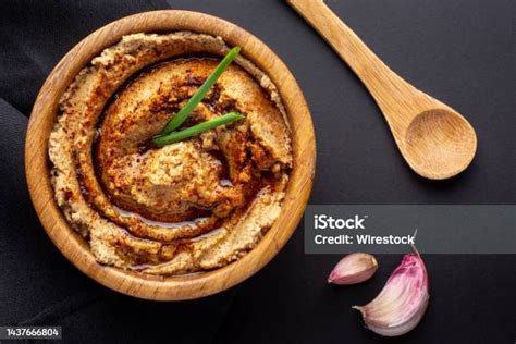 검은 테이블에 나무 숟가락과 마늘 조각이 있는 나무 그릇에 후무스의 오버헤드 샷 갈색에 대한 스톡 사진 및 기타 이미지 갈색 건강한 생활방식 건강한 식생활 Istock
