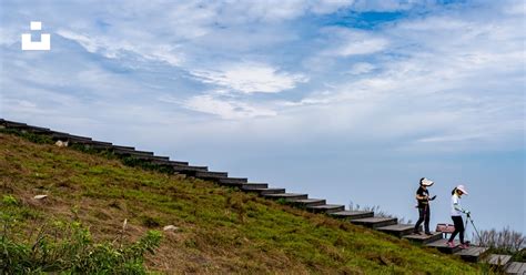 언덕 위에 서 있는 두 사람이 기차를 바라보고 있다 사진 Unsplash의 무료 사람의 이미지