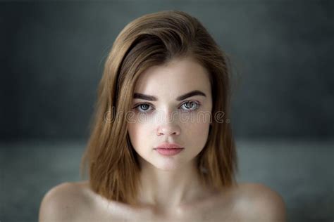 Сексуальная маленькая девочка в нижнем белье и пальто стоит полагающся против колонки Стоковое