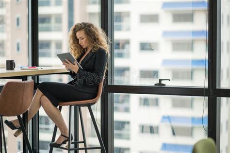 Молодая красивая бизнес леди возле окна с помощью планшетный компьютер