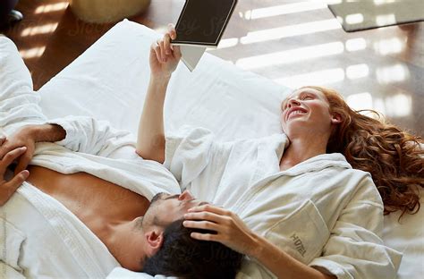 Woman Reading Book For Man While Lying In Bed By Stocksy Contributor ALTO IMAGES Stocksy