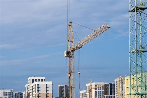 Premium Photo Crane And A Building Under Construction Against A Blue Sky Background