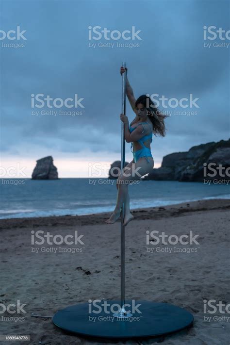 아름다운 해변에서 그에게 극 춤을 수행하는 젊은 백인 소녀 프랑스 헨다야 해변의 모래위에 있는 폴 댄스곡 아침에 가장 먼저 파란 시간 가냘픈에 대한 스톡 사진 및 기타