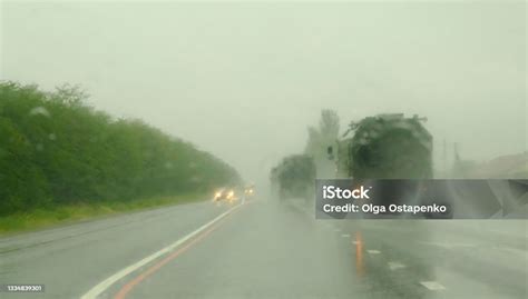 고속도로에 현대 군용 차량의 기둥 비로 덮인 자동차 앞 유리를 통해 볼 수있는 디포커스 트래픽이 가을에 전쟁에 대한 스톡 사진 및 기타 이미지 Istock