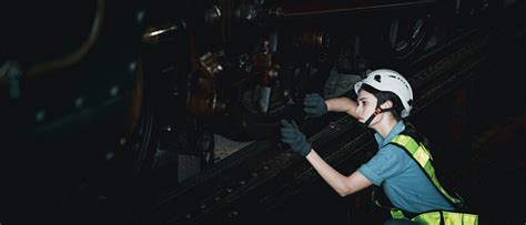 엔지니어가 공장에서 일하고 있습니다 기계의 준비 상태를 수리하고 검사하는 것을 돕는 작업자 기계 기술자가 오작동하는 열차 차고에서 엔진을 유지 관리하고 있습니다 수리에 대한