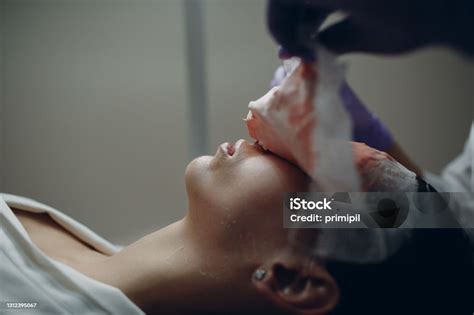 Alginate 얼굴 마스크 제거 과정 주걱을 들고 있는 미용사의 여성 손 미용사 사무실에서 소파에 누워있는 여성 뷰티 스파 살롱의 페이셜 스킨케어 20 24세에 대한 스톡
