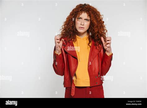 Portrait Of An Attractive Confused Redhead Young Woman Standing
