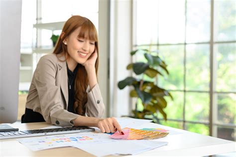 젊은 아시아 여성 그래픽 디자이너는 사무실에서 다이어그램 색상 및 컴퓨터 그래픽을 작업합니다 손가락에 초점을 맞춥니다 Cmyk에