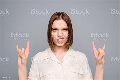 클로즈 업 사진 펑키 놀라운 그녀 그녀의 여자 얼굴 표정 무례한 유치 한 로커 기호 기호 방문 좋아하는 그룹 콘서트 Overjoyed 뿔 착용 캐주얼 흰색 셔츠 고립 된