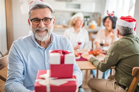 크리스마스 선물이 든 상자를 손에 들고 카메라를 직접 바라보는 노인의 초상화 4 명에 대한 스톡 사진 및 기타 이미지 4 명