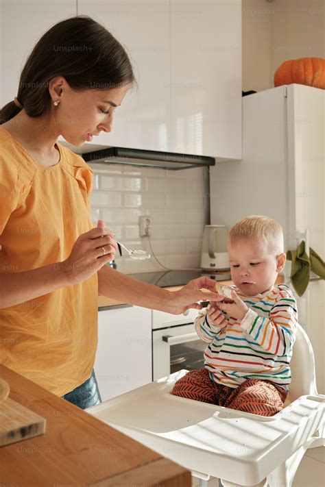 아기에게 음식 한 숟가락을 먹이는 여자 사진 Unsplash의 부엌 이미지
