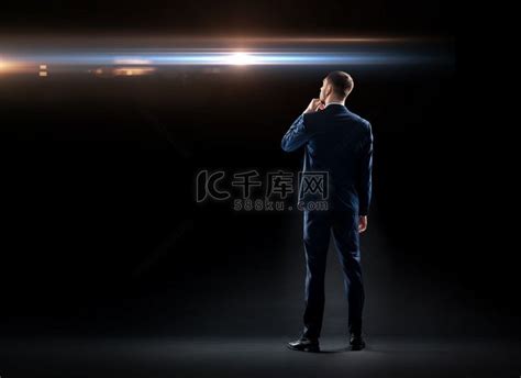 商业、技术和人的概念 在黑色背景下穿着激光西装的商人。高清摄影大图 千库网