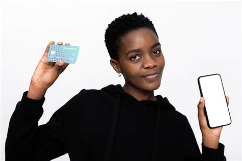 기뻐하는 아프리카계 미국인 흑인 여성은 신용 카드와 휴대폰을 들고 빈 흰색 화면을 손에 들고 카메라 모바일 쇼핑 애플리케이션을 보여줍니다 여성 쇼핑객 추천 앱 폰 뱅킹