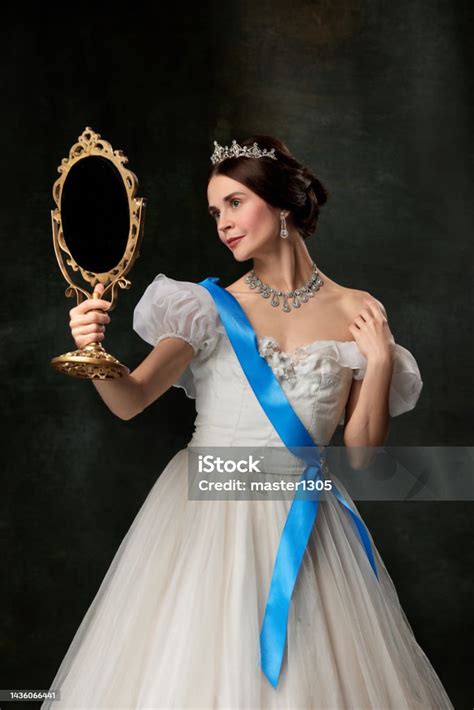 젊은 여왕 어두운 배경에 고립 된 르네상스 스타일의 드레스를 입은 중세 왕실의 이미지에서 사랑스러운 소녀의 초상화 시대 아름다움 역사 예술의 비교 거울에 대한 스톡 사진 및