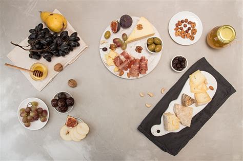 식품 구성 치즈 플레이트 치즈 고기 다양 한 과일 및 견과류를 건조 조각 케 케 묵은 치즈 햄 절인된 매 실 포도 올리브 무화과 배 꿀 아몬드 캐슈 호두 회색 콘크리트