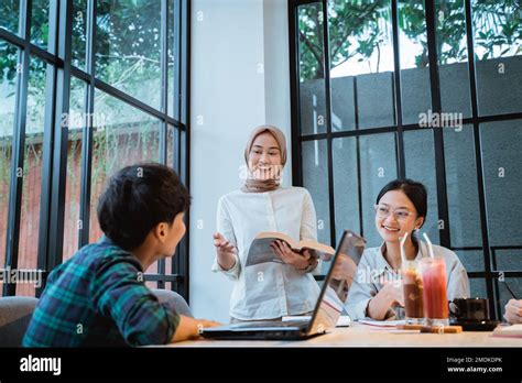Two Girls Discussing With Their Friends While Doing Assignments In