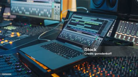디지털 오디오 워크 스테이션 소프트웨어의 사용자 인터페이스를 보여주는 노트북 화면현대 음악 레코드 스튜디오 제어 데스크 이퀄라이저 믹서 및 전문 장비 페이더 슬라이더 레코드
