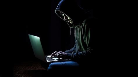 Premium Ai Image Hacker In The Hood Silhouette In The Dark With Laptop