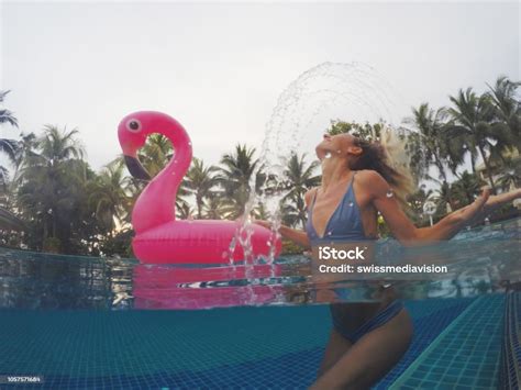 젖은 머리를 던지기 풍선 플라밍고와 수영장을 즐기는 휴가에 젊은 여자의 수 중 샷 사람들이 여행 휴가 이국적인 장소 개념에 20 29세에 대한 스톡 사진 및 기타 이미지