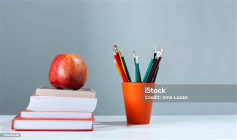 오렌지 연필 홀더 오픈 하드 백 책 일기 빨간 사과와 흰색 테이블에 책의 스택에 페이지를 부채질 책 스태킹 학교 개념으로 돌아갑니다 공간을 복사합니다 교육 학습 배경 0명에