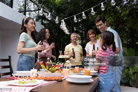 다민족 가족은 집에서 정원에서 야외 파티를 즐기고 즐거운 시간을 보내고 긴 주말 개념의 파티를 축하합니다 가족에 대한 스톡 사진
