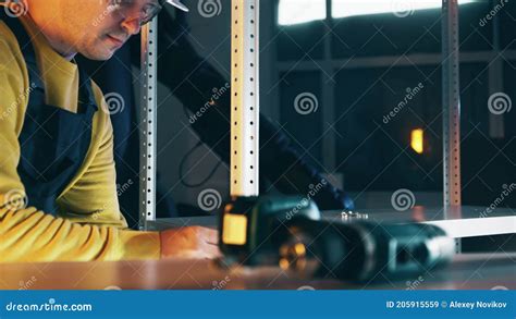 Male Worker Wearing Hard Hat Assembles The Industrial Equipment Stock