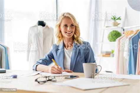 의류에 아이디어를 터 닝입니다 아름 다운 젊은 여 자가 그녀의 스튜디오는 선반에 매달려 옷 근처에 스케치 작업 그리기에 대한 스톡 사진 및 기타 이미지 Istock