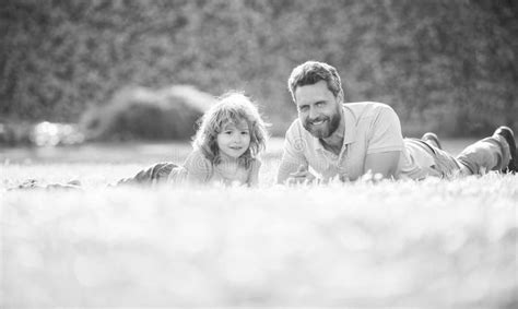 Família Feliz De Pai E Filho Relaxa Na Infância De Grama Verde No Verão