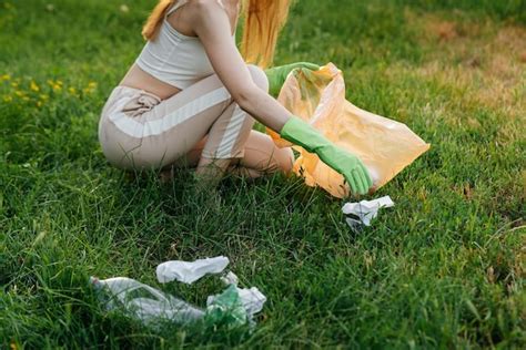 Premium Photo A Girl In The Park At Sunset Is Engaged In Garbage Collection In The Park