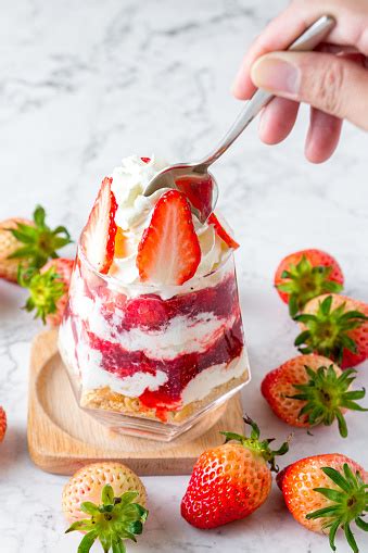 대리석 테이블 위에 놓인 유리에 딸기 무스 케이크 뚜렷하게 겹쳐진 딸기 무스 케이크는 얇게 썬 신선한 딸기로 아름답게 장식되어 있습니다 건강한 생활방식에 대한 스톡 사진 및