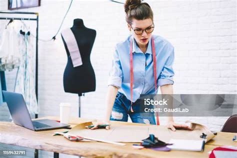 바느질을위한 악기와 바탕 화면에 서 새로운 트렌디 한 의류의 스케치를보고 광학 안경 전문 여성 Couturier 오른쪽 조치에 생각 현대 맥북 컴퓨터 공예에 대한 스톡 사진