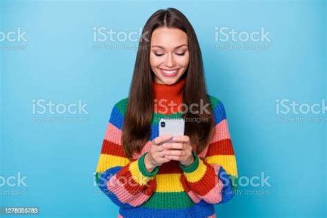 긍정적 인 쾌활한 소녀 블로거 Chilling Use 스마트폰 팔로우 공유 구독 소셜 미디어 뉴스 웨어 무지개 스타일 스웨터 블루 컬러 배경 인플루언서에 대한 스톡 사진 및