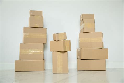 이동을위한 골판지 상자 더미 흰색 벽이있는 빈 방과 바닥에 브랜드가없는 바코드가있는 골판지 상자 상품 배달 쇼핑 회색 벽 배경에 골판지 상자 상자에 대한 스톡 사진 및 기타