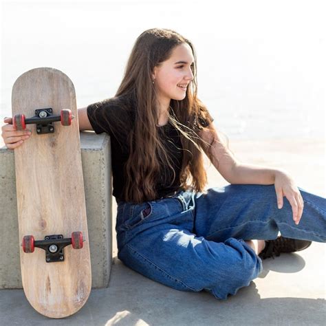 Free Photo Young Girl With Long Hair Holding Her Skateboard Outdoors
