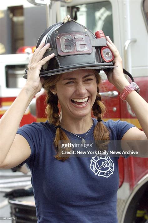 Actress Diane Farr Tries On A Firefighters Helmet During A Break In