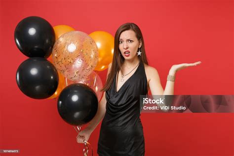 검은 드레스 복사 공간에 따로 손을 가리키는 풍선 축 하 하는 붉은 바탕에 격리 공기를 들고 초조 젊은 여자를 염려 한다 해피 뉴가 어 생일 이랑 휴일 파티 개념 2019