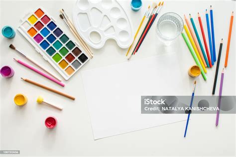 드로잉 레슨에서 작가의 작업장 화려한 페인트와 연필로 둘러싸인 흰색 종이 위에서 볼 수 있습니다 취미 여러 가지 빛깔의 배경 텍스트 나 그림을위한 장소 0명에 대한 스톡