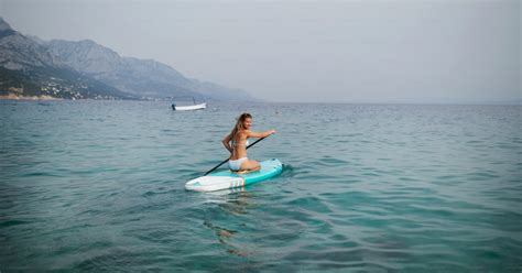 바다에서 Sup 보드에 비키니를 입은 젊은 아름다운 여자 바다에서 노를 젓는 스탠드업 패들보딩을 하는 모험 소녀 뒷모습 사진 Unsplash의 크로아티아 이미지