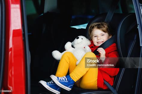 카시트에 앉아 봉제 인형 장난감을 들고 차창 밖으로 보이는 유아 소녀 차로 여행하는 작은 아이 도로에 어린이 안전 가족 여행 및 휴가 교통 수단 좌석에 대한 스톡 사진 및
